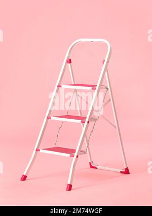 Maintenance ladder on pink background Stock Photo - Alamy
