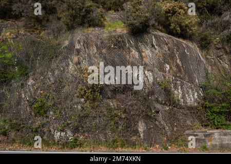 Protective wire mesh against falling rocks. Protection or caution on ...