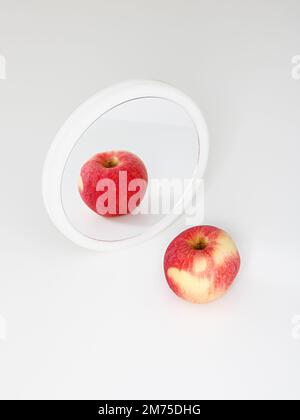 A vertical shot of an apple reflecting in a mirror as a cut one Stock ...