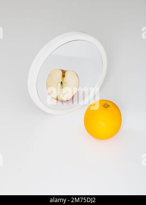 A vertical shot of an apple reflecting in a mirror as a cut one Stock ...