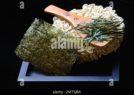 Nori, cut paper-like sheet of seaweed and Asian noodles with chopsticks ...