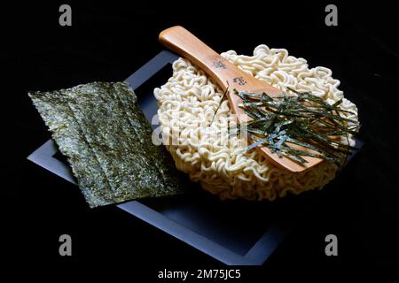 Nori, cut paper-like sheet of seaweed and Asian noodles with chopsticks ...
