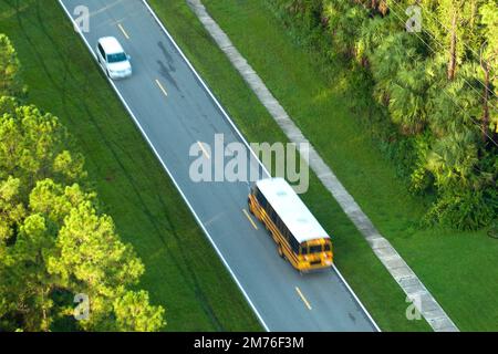 Top view of standard american yellow school bus picking up kids at ...