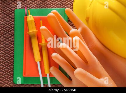 Notepad building helmet electricians gloves electrical tester on ...