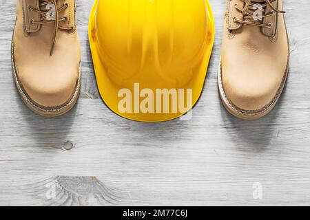 Waterproof lace boots building helmet protective gloves on wooden board ...