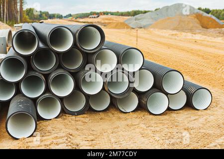 pile of big water pipes on construction site Stock Photo - Alamy