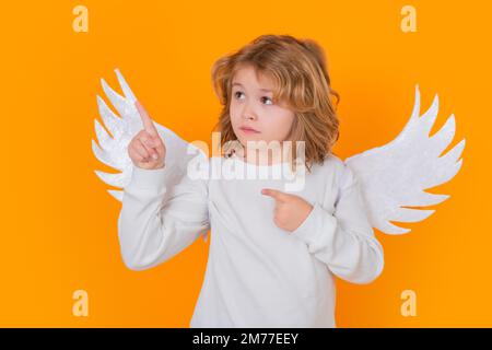 Child angel pointing finger, point gesture. Kid wearing angel costume ...