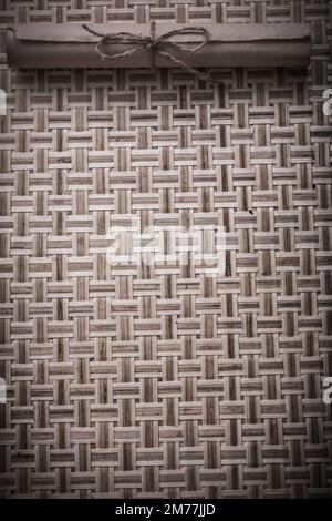 Vintage rolled document on wicker wooden mat Stock Photo - Alamy