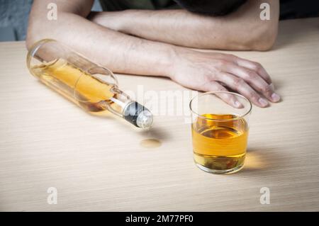 A drunk young guy passed out at the bar surrounded by half-finished ...