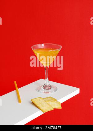 A Cold Bronx Cocktail drink and Cracker Biscuit isolated on blue ...