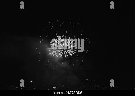 A grayscale of amazing colorful New Year fireworks against dark ...