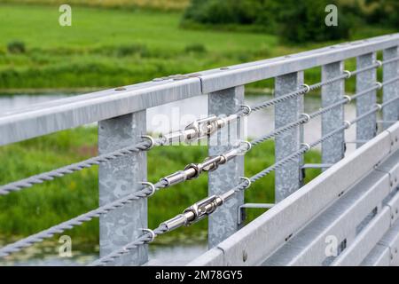 Turnbuckles connecting the safety ropes at the railing on the bridge ...