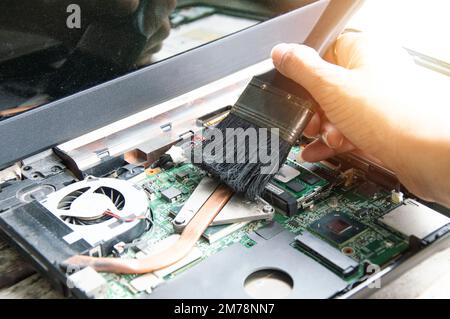 technician using brush Clean the dusty notebook Stock Photo - Alamy