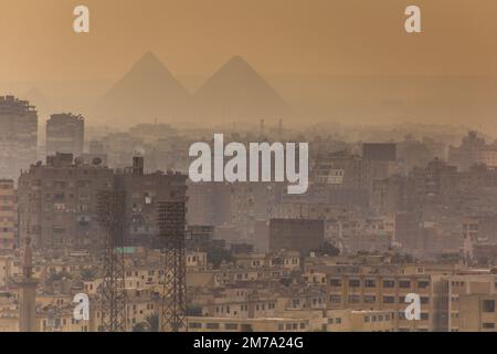 View of misty Cairo skyline with pyramids in the background, Egypt ...