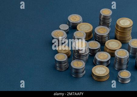 Piles of Mexican pesos coins arranged in the corner of the image with ...