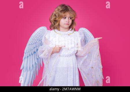 Child angel pointing finger, point gesture. Kid wearing angel costume ...