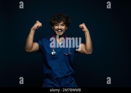 Young doctor with win gesture isolated on blue background Stock Photo ...