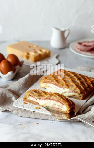 puff with ham and cheese cut on a rectangular plate on a kitchen table ...