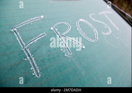 The word FROST scratched in the icy surface of a frosted over car ...