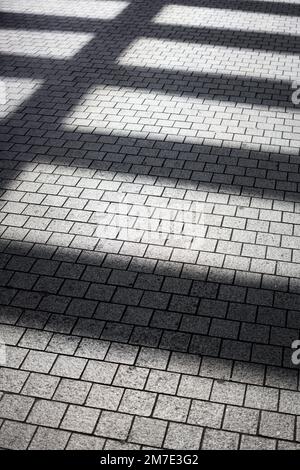 Shadow patterns cast across a tiled paved concrete pavement Stock Photo ...