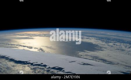 The sun's glint beams off a partly cloudy South Pacific, as seen from ...