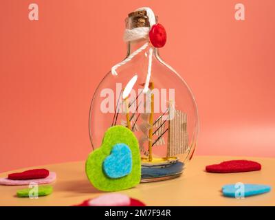 Ship in a bottle and hearts on a pink background. Close-up Stock Photo ...