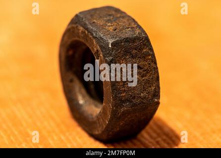 A closeup shot of a rusty corroded nut and bolt on a wooden structure ...