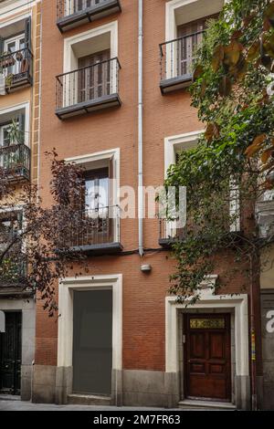 Facade of a narrow building built with exposed clay brick, balconies ...