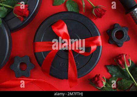 Ribbon wrapped dumbbell barbell weight plate and red rose. Love gift ...