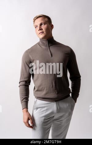 Portrait of a blond german model with a brown sweater on a white ...