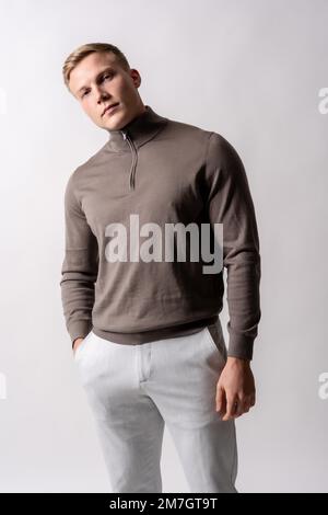 Portrait of a blond german model with a brown sweater on a white ...