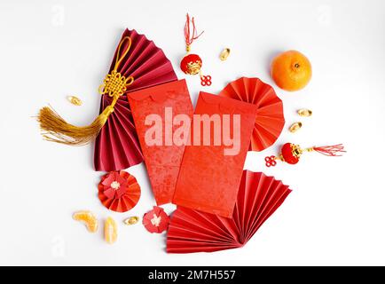 Red envelopes and Chinese symbols on light yellow background with space ...