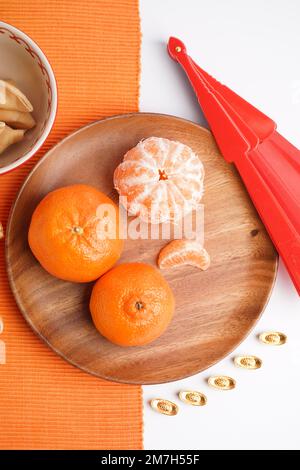 Plate with fortune cookies and mandarins on yellow background, closeup ...