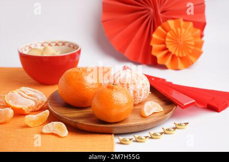Plate with fortune cookies and mandarins on yellow background, closeup ...
