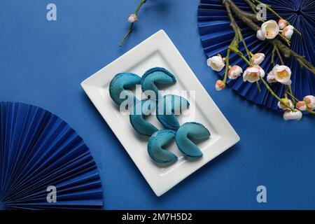 Plate with fortune cookies and Chinese symbols on blue background ...