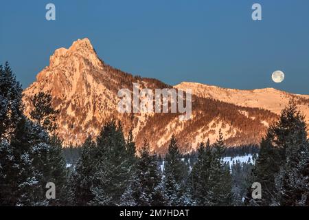 full moon setting over ross peak in the bridger mountains in winter ...