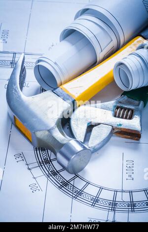Adjustable spanner rolled up blueprints and claw hammer construction ...