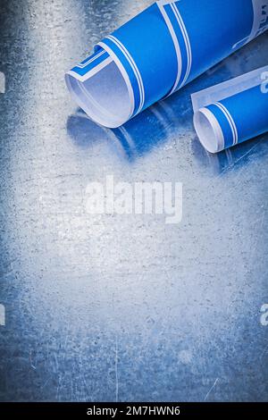 Blue rolled blueprints on metallic background construction concept ...