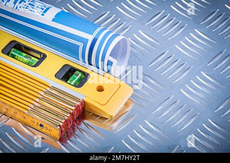 Blue rolled blueprints on corrugated metal background construction ...
