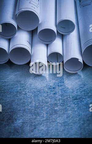 Rolled engineering drawings on scratched vintage metallic background ...
