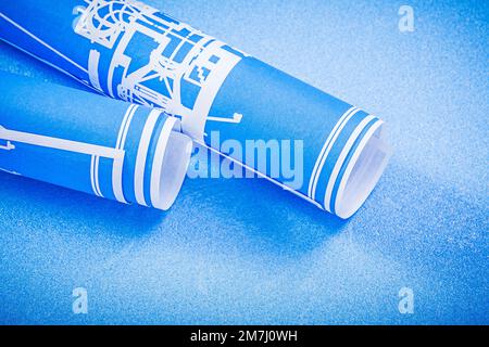 Blue rolled engineering drawings on metallic background construction ...
