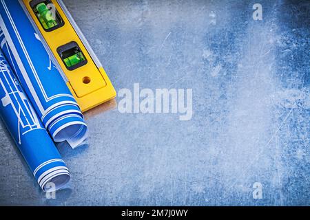 Rolled up construction drawings level on metallic background Stock ...