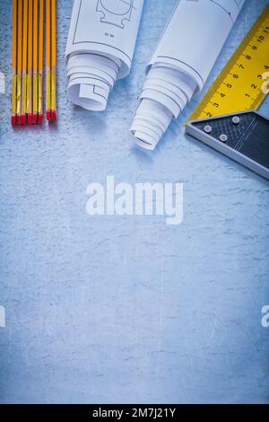 Wooden meter rolls of blueprints square ruler on metallic background ...