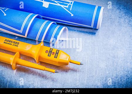 Yellow electrical tester blue engineering drawings on metallic ...
