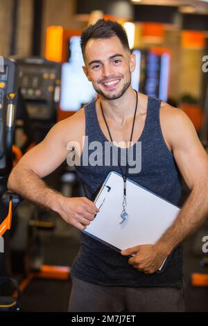 Handsome Personal Trainer With Stopwatch In A Fitness Center Gym ...