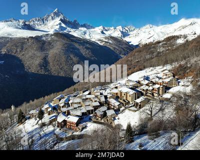 Winter view from above of Ostana, an Occitan village below Monviso. It ...