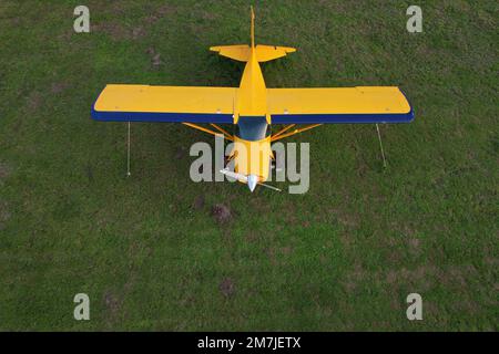 small yellow plane used for short trips seen from above parked on a ...