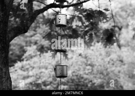 Three tin pots and pails hanging on a rope as a garden decoration Stock ...