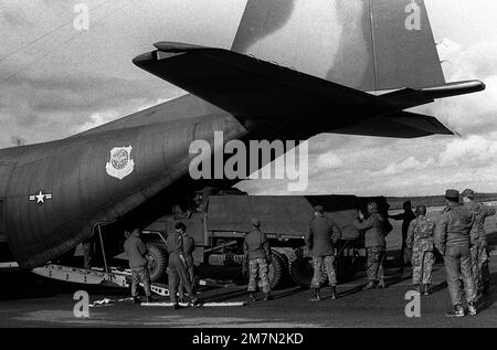 A Military Airlift Command (MAC) C-130 Hercules aircraft drops a pallet ...