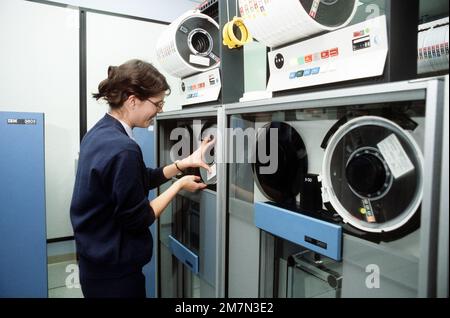 A computer operator changes the tape on an IBM 370/168 computer at the ...